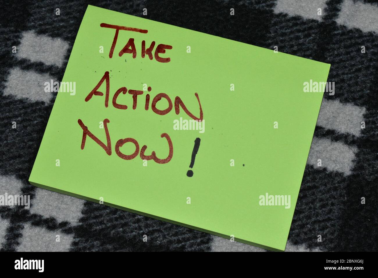 Close up of a fluorescent green post-it note in black & white ...