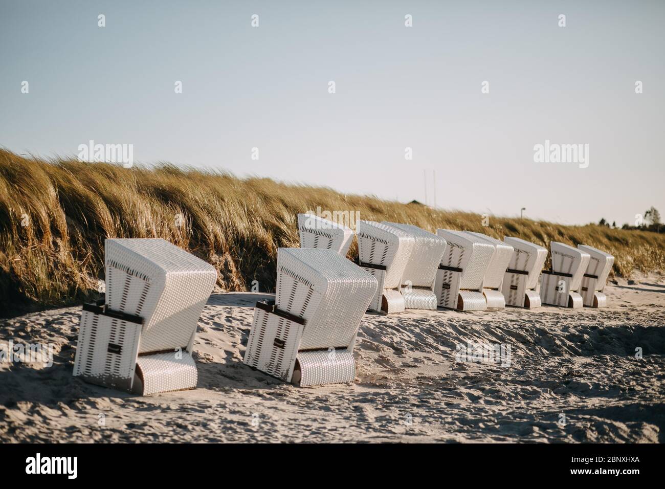 photo of roofed wicker beach chairs at sunset Stock Photo - Alamy