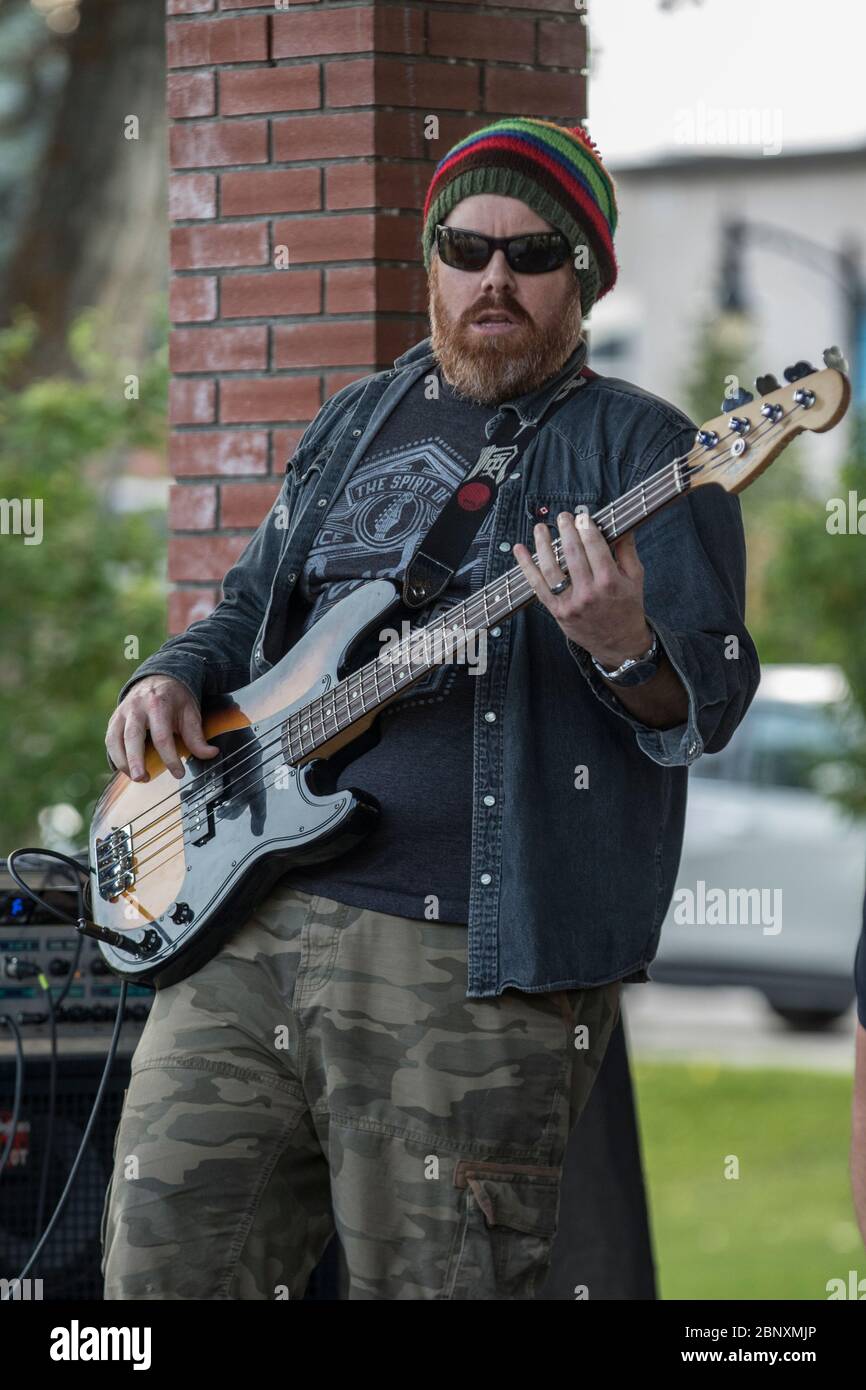 Bass player, in rock and roll band, performing at outdoor concert Stock ...