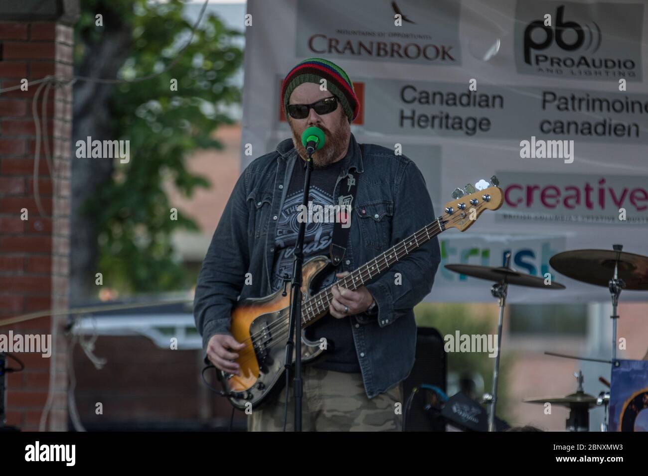Bass player, in rock and roll band, performing at outdoor concert Stock ...
