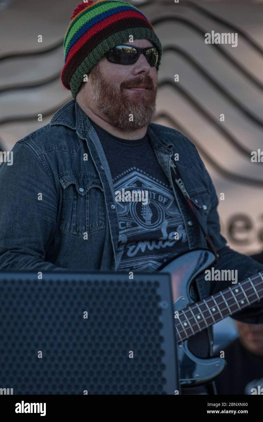 Bass player, in rock and roll band, performing at outdoor concert Stock ...