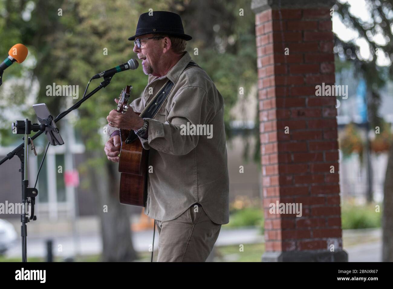 Folk singer performing at oudoor concert. Singing and playing guitar ...