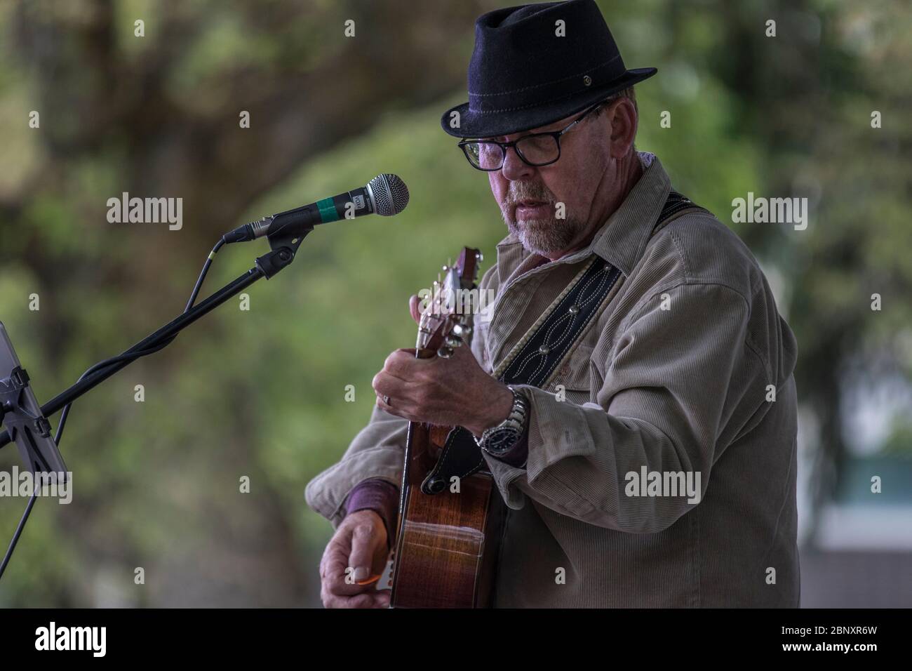 Folk singer performing at oudoor concert. Singing and playing guitar ...