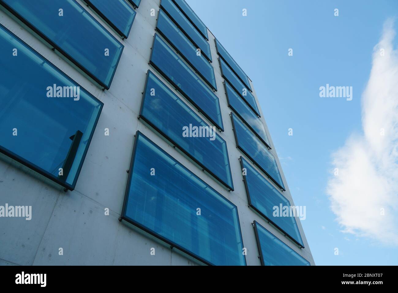 a facade of a modern corporate building with large square window in ...