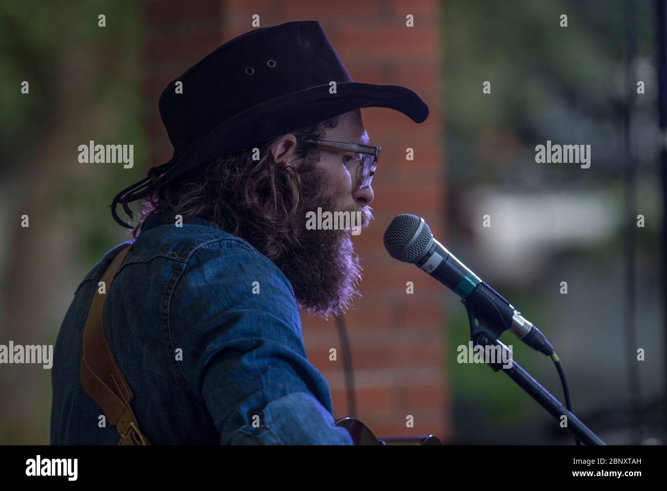 Bearded folk singer performing at oudoor concert. Singing and playing ...