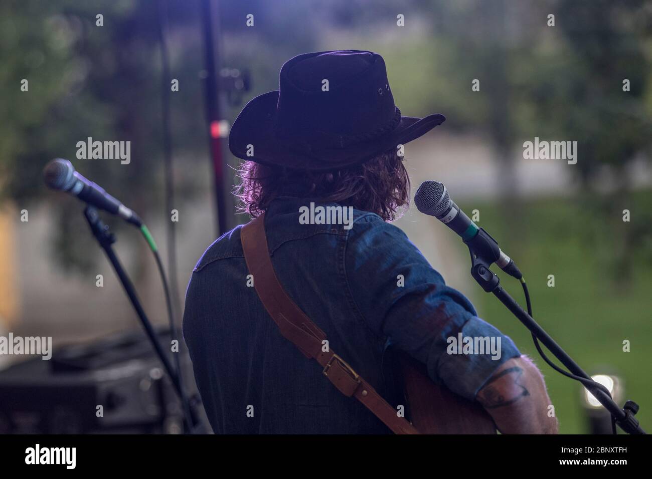 Bearded folk singer performing at oudoor concert. Singing and playing ...