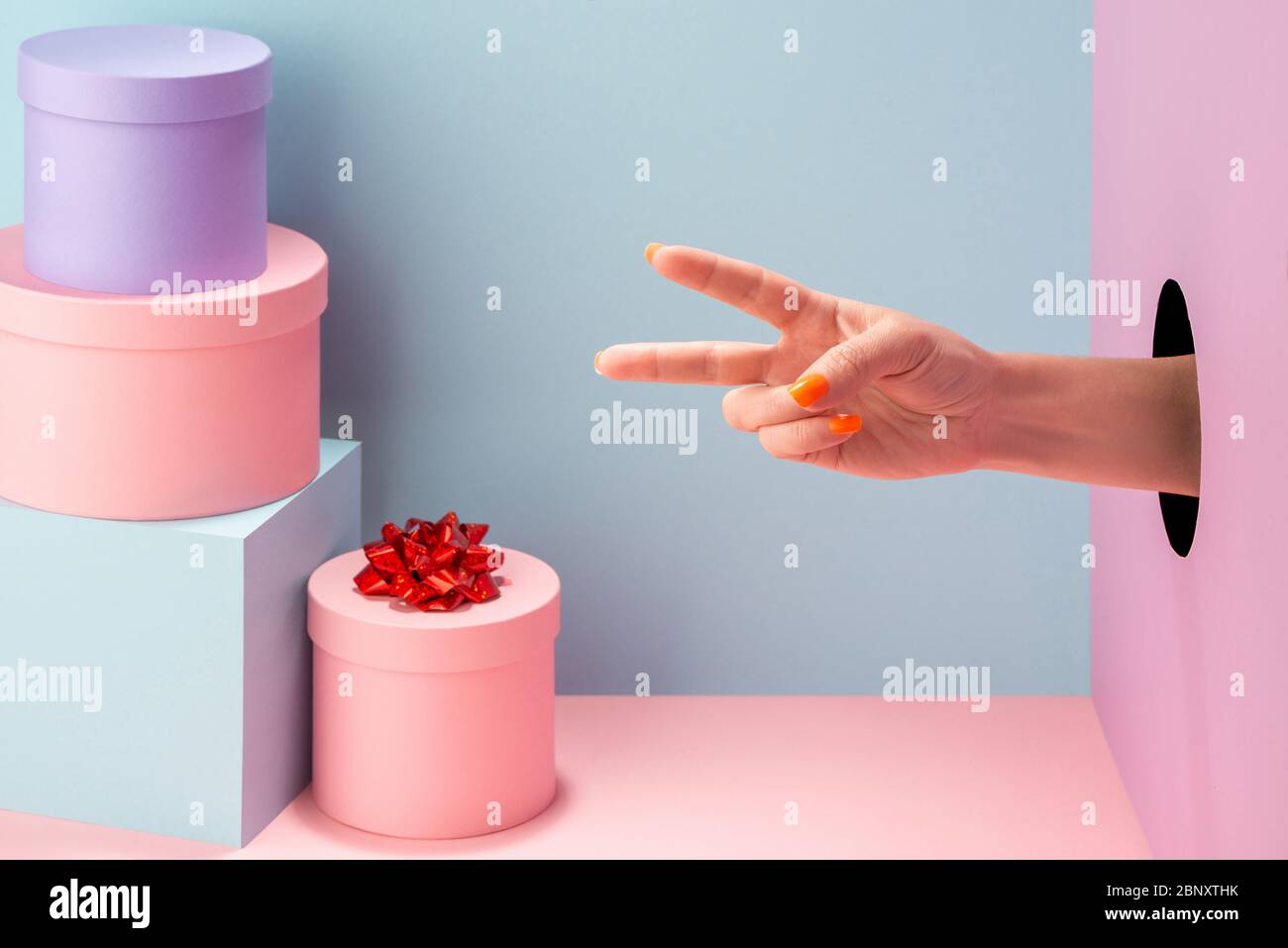 Hand showing a peace sign on blue and pink background Stock Photo - Alamy