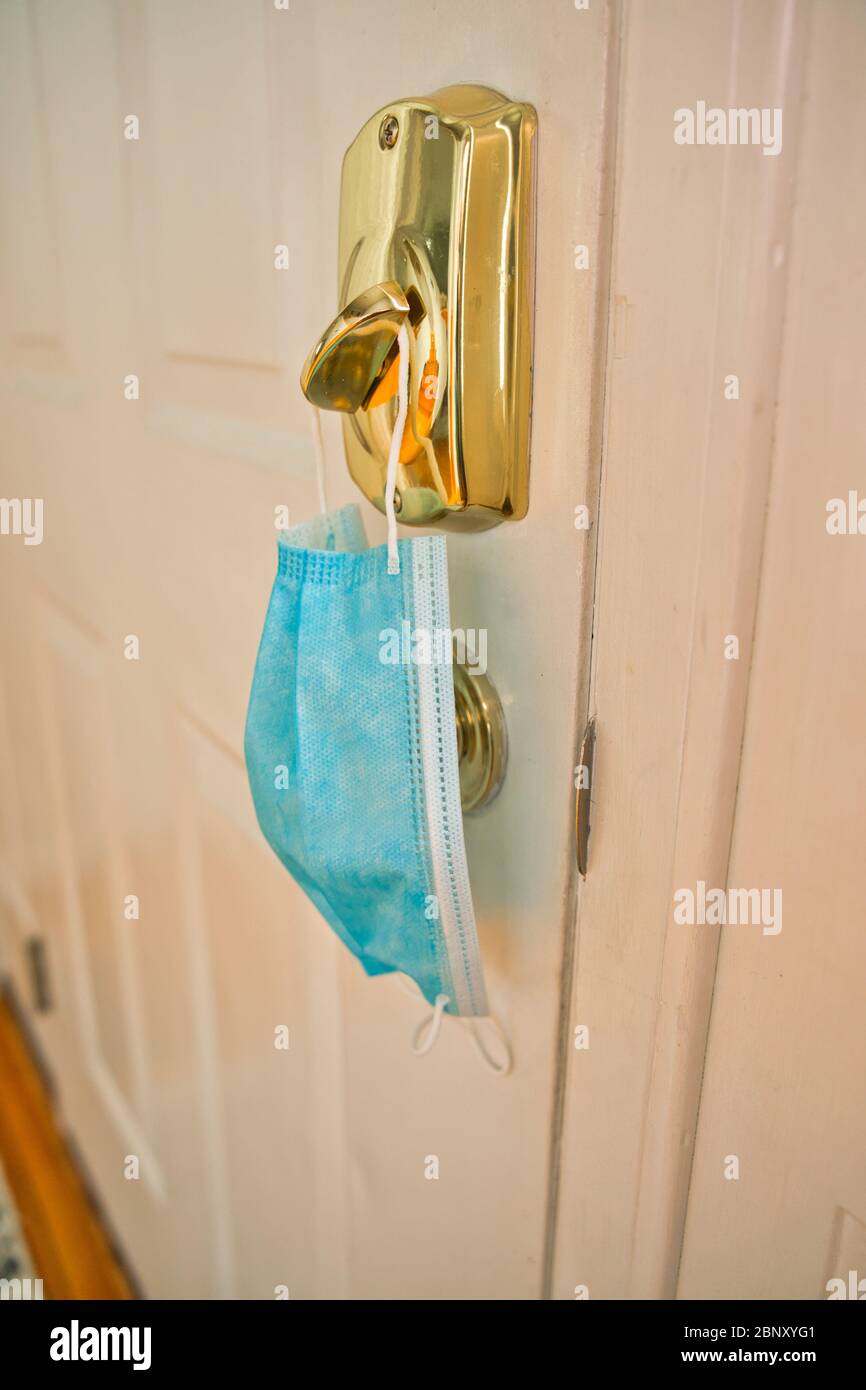 Blue mask hanging from lock as a reminder to wear facemask when leaving ...