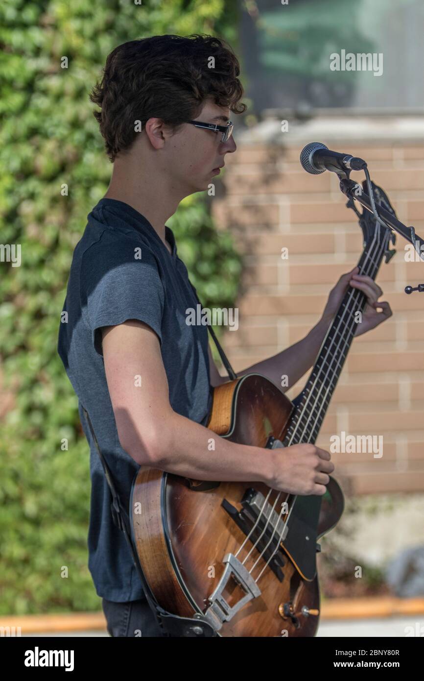 Teenage male bass player in band, playing at out door concert Stock ...