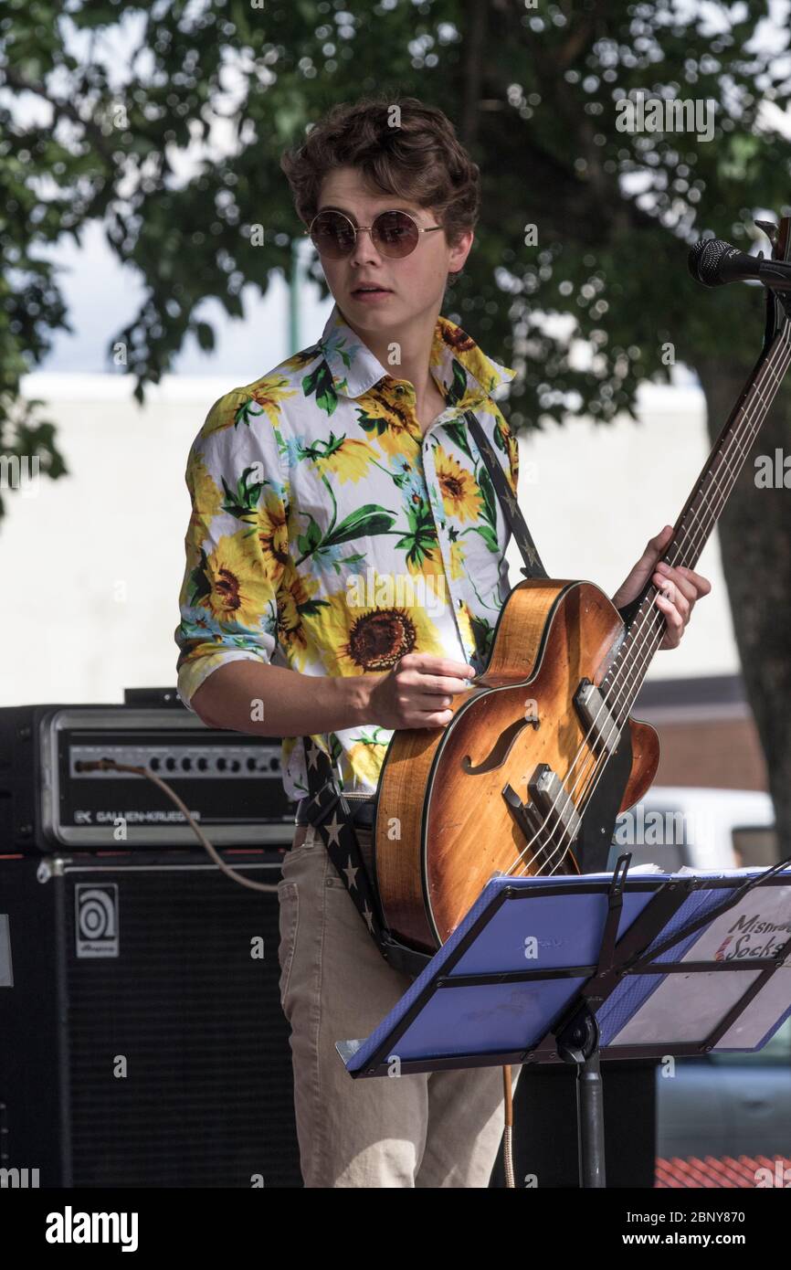Teenage male bass player in band, playing at out door concert Stock ...
