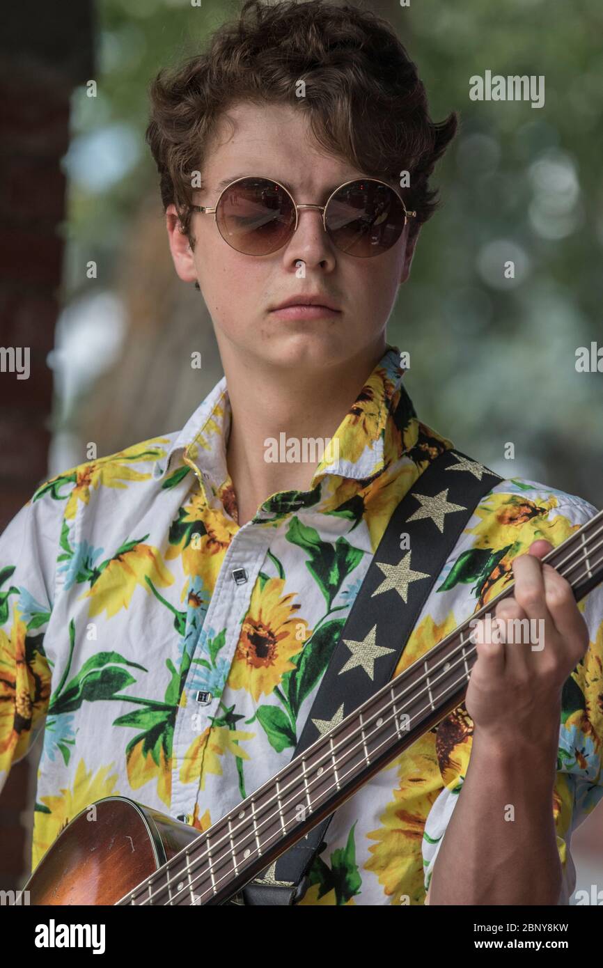 Teenage male bass player in band, playing at out door concert Stock ...