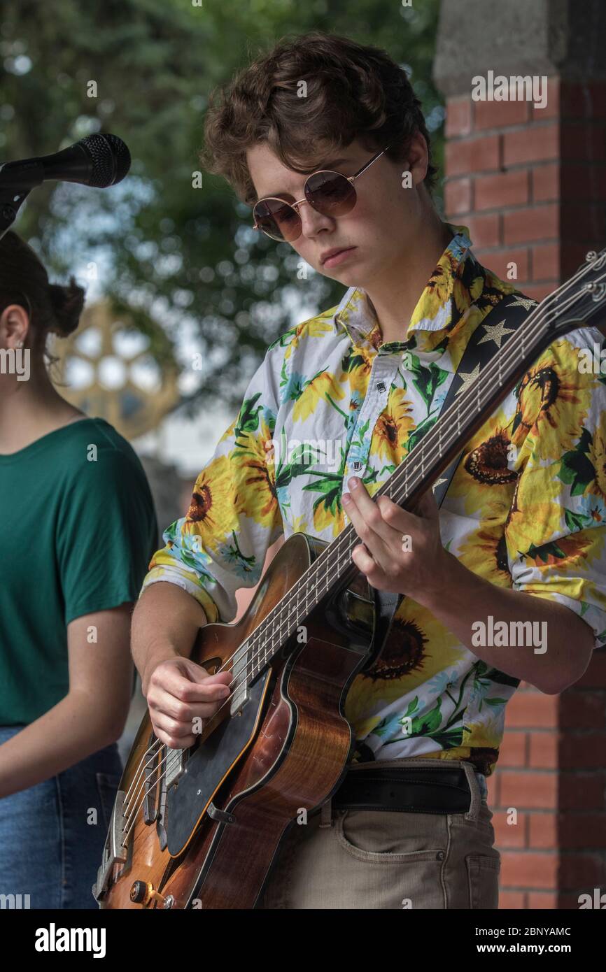 Teenage male bass player in band, playing at out door concert Stock ...