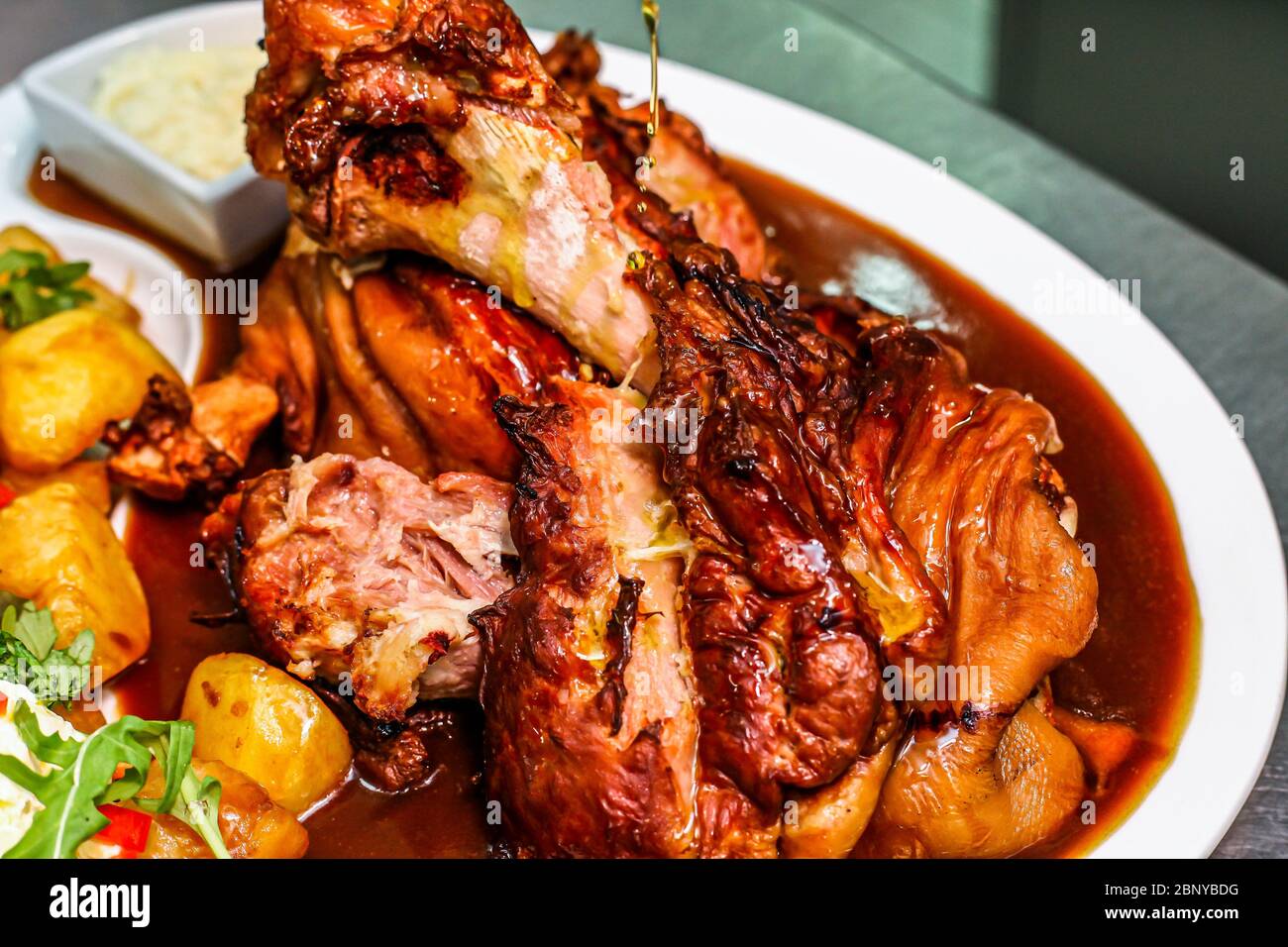 Roasted Pork Knuckle with succulent sauce, kaymak and vegetables Stock ...