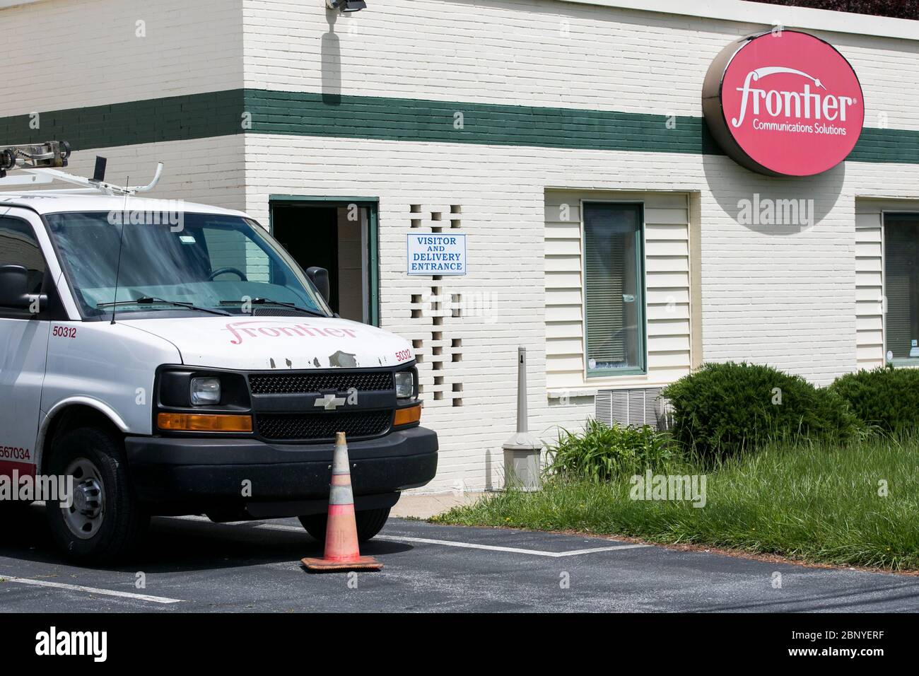 A logo sign outside of a facility occupied by Frontier Communications ...