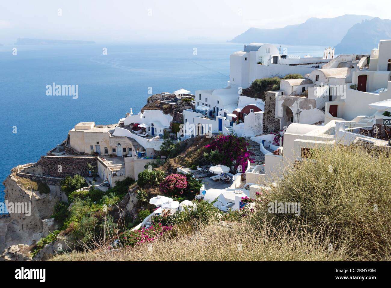 Traditional white washed Greek houses along the coastline with blue ...