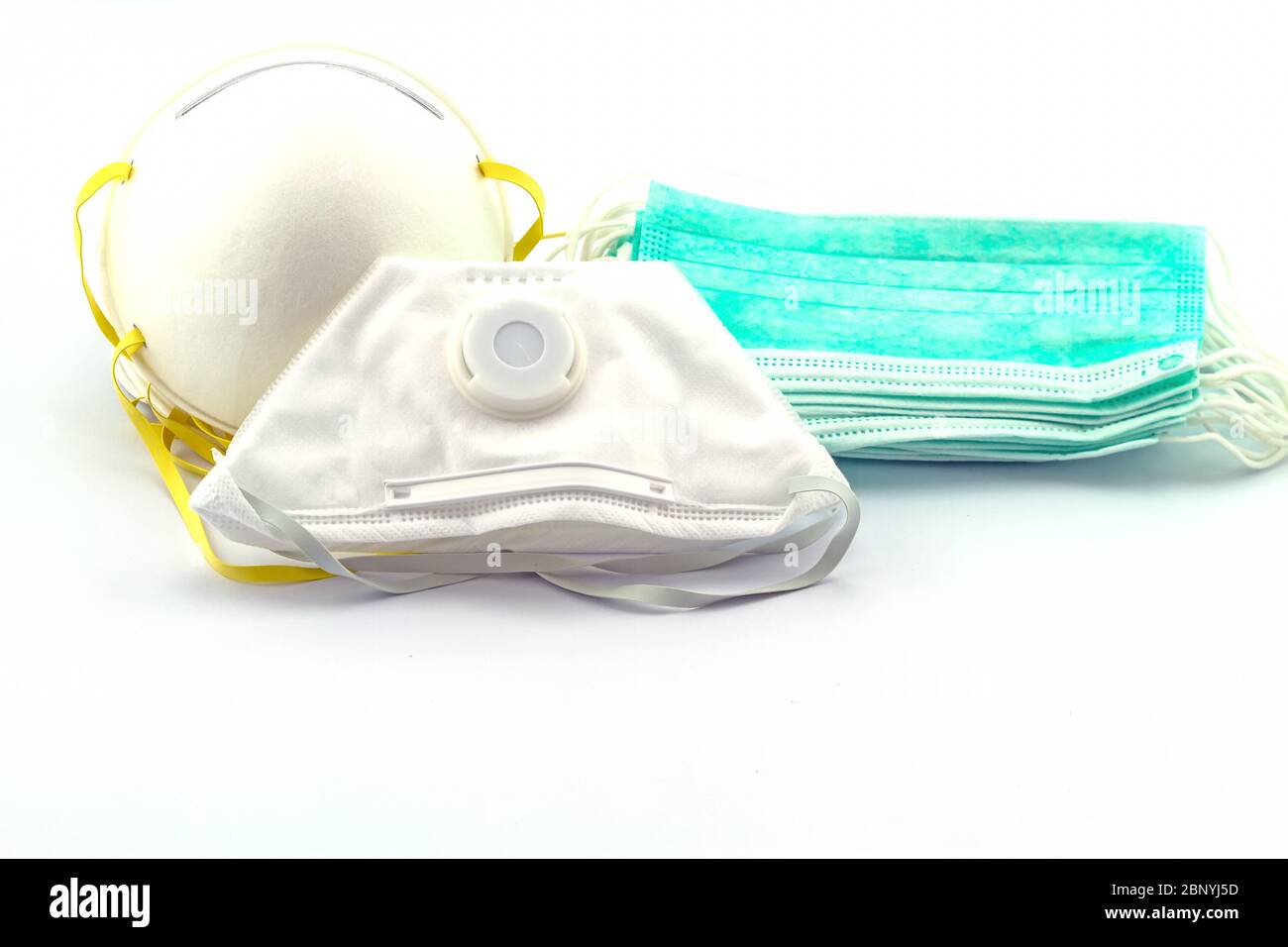 Close up of white mask and blue surgical mask stack on white background ...