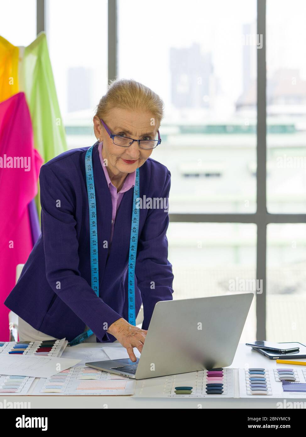 A senior designer uses her laptop computer to research information for ...