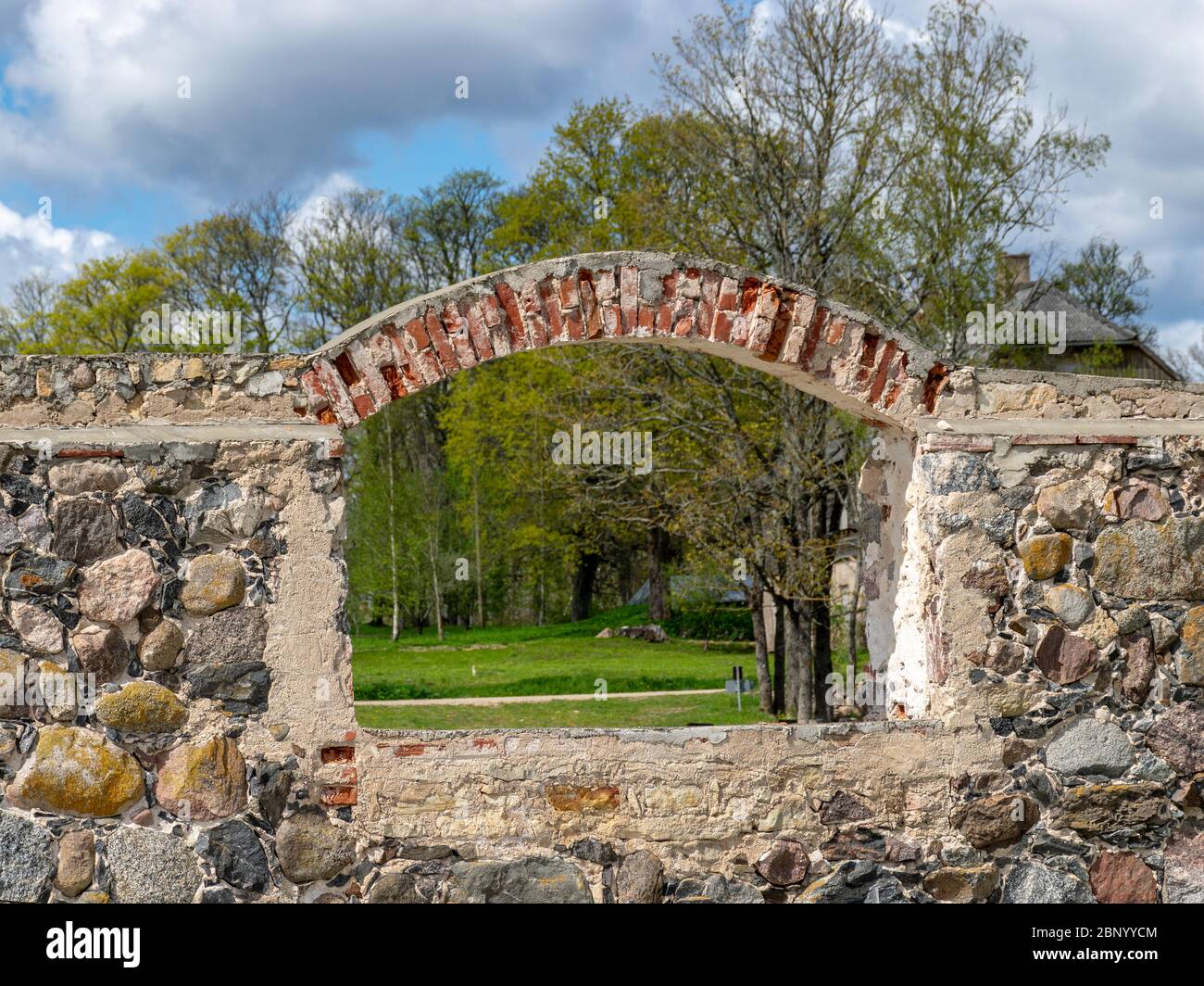 spring landscape with an old stone building wall and arched windows ...