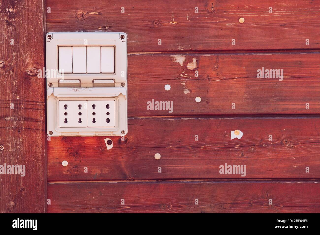 Dark red wooden background with ruined and worn european electrical ...