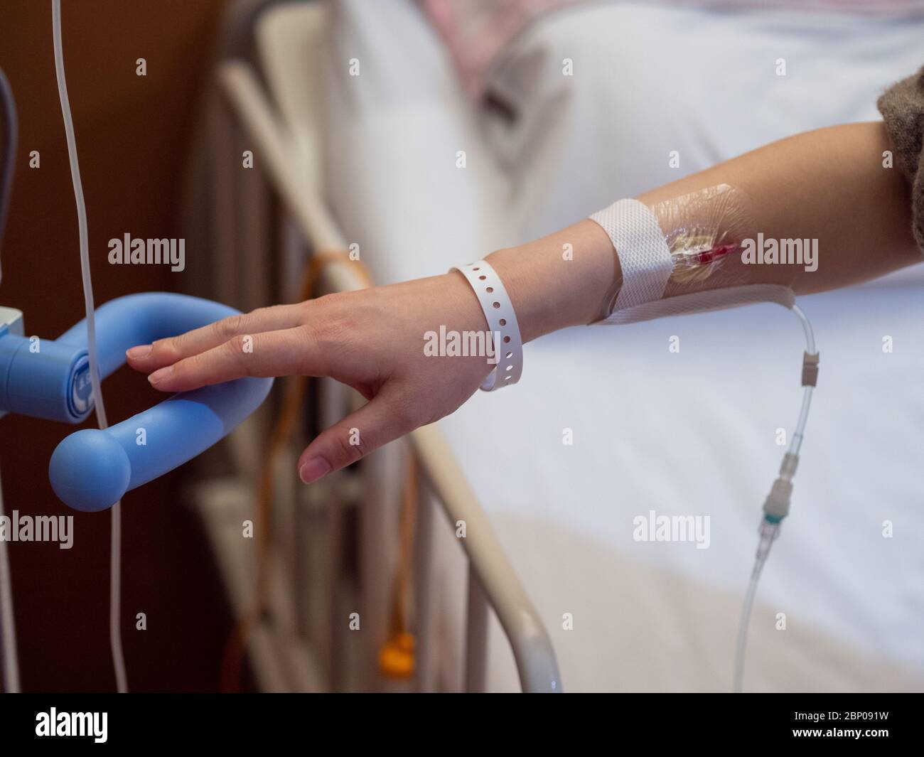 A patient's hand holding on to a handle for support Stock Photo - Alamy