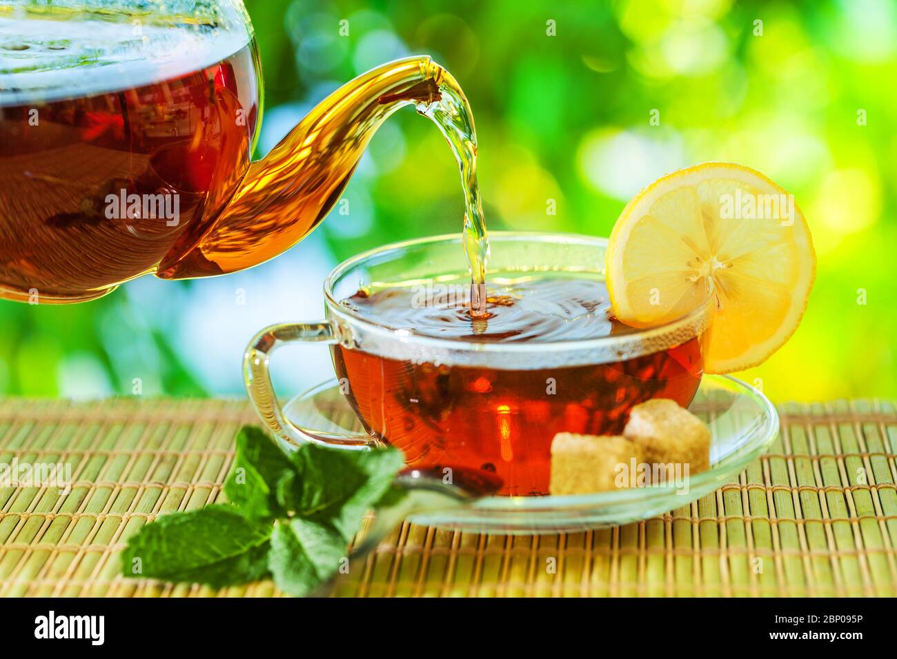 Tea ceremony, pouring tea from a teapot into a tea cup on a background ...