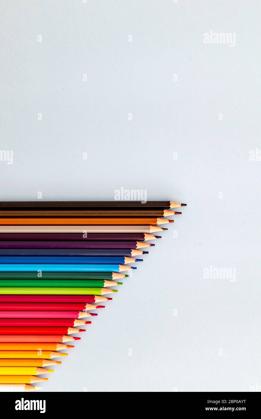 a collection of colourful pencils lined up together going from light to ...