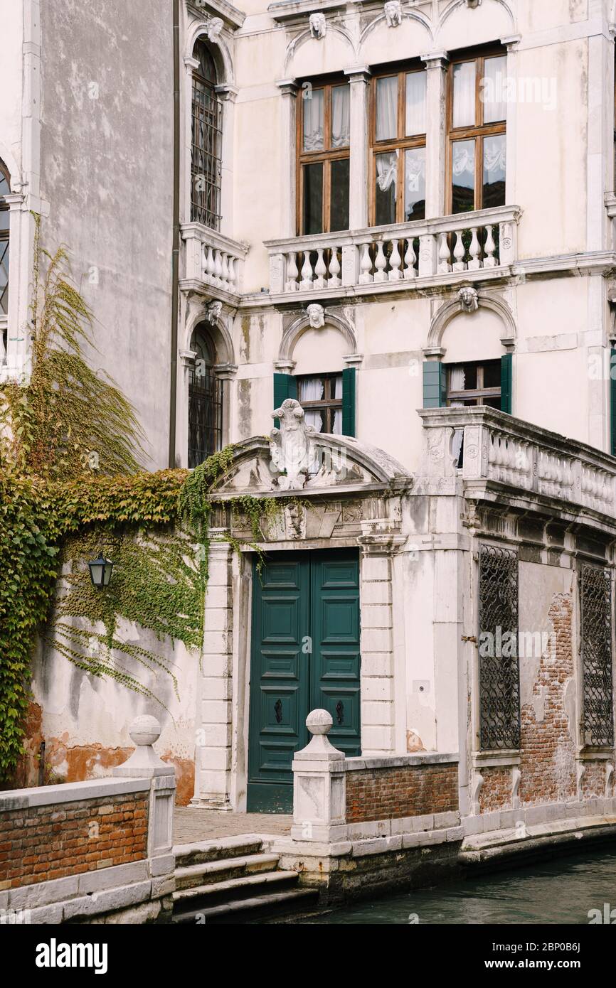 Beautiful stone arched entrance to the building, a green door and ...