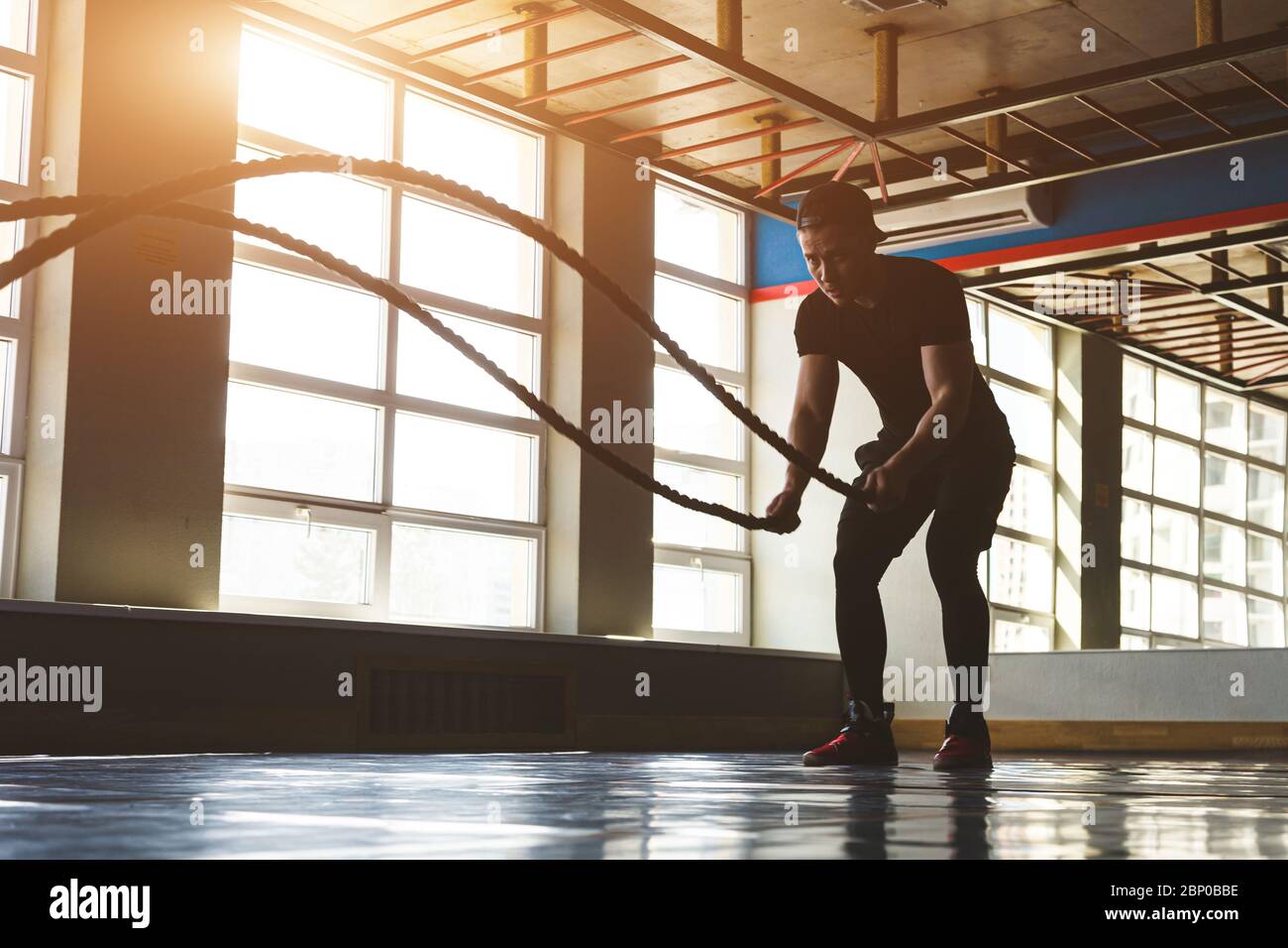 Exercise with ropes. The athlete is training in the gym opposite large ...