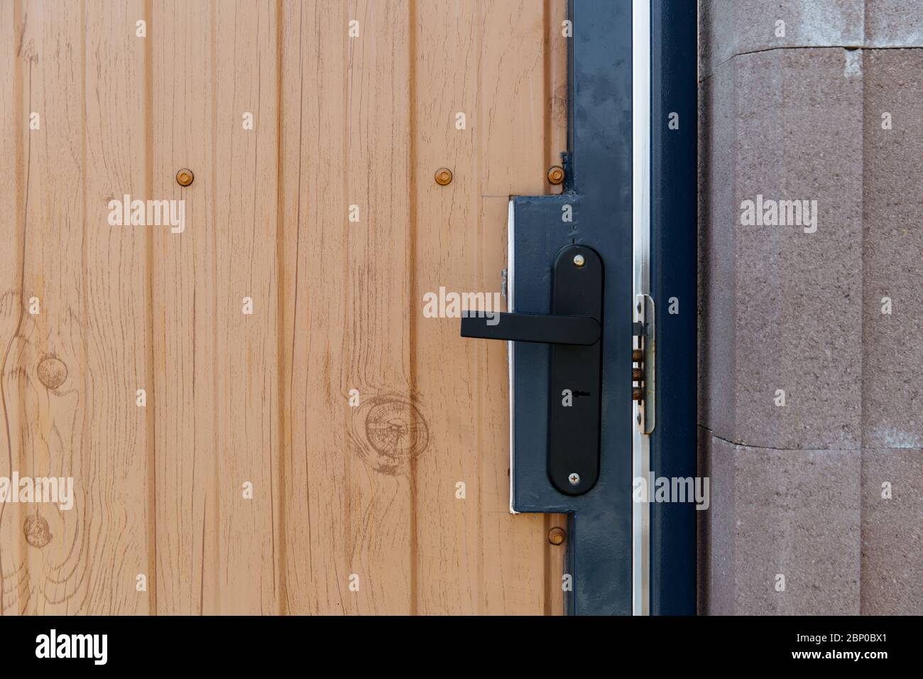 Detail of a closed door with a lock handle.Metal handle and lock on the ...