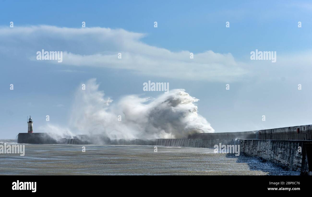 Huge waves crash over harbour wall onto lighthouse during huge storm on ...