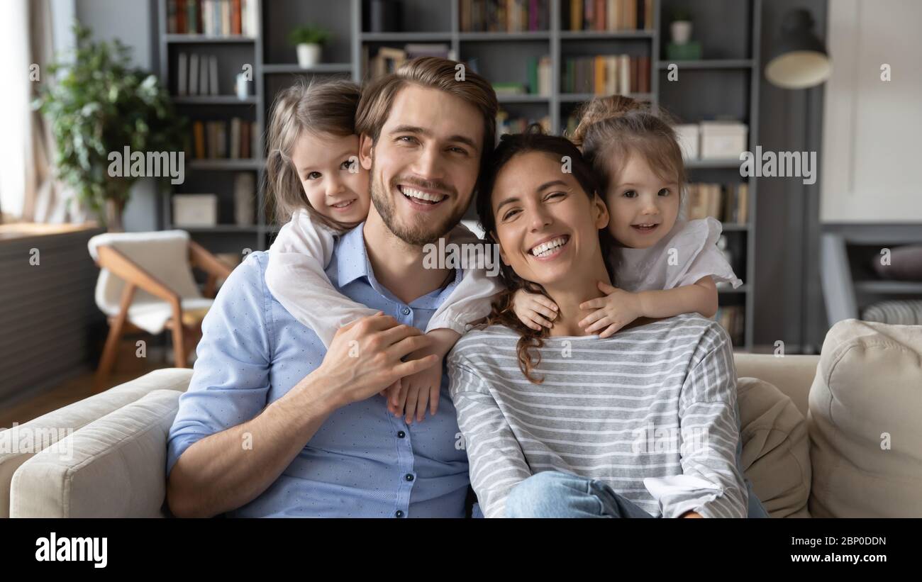Portrait of young family with small daughters at home Stock Photo - Alamy