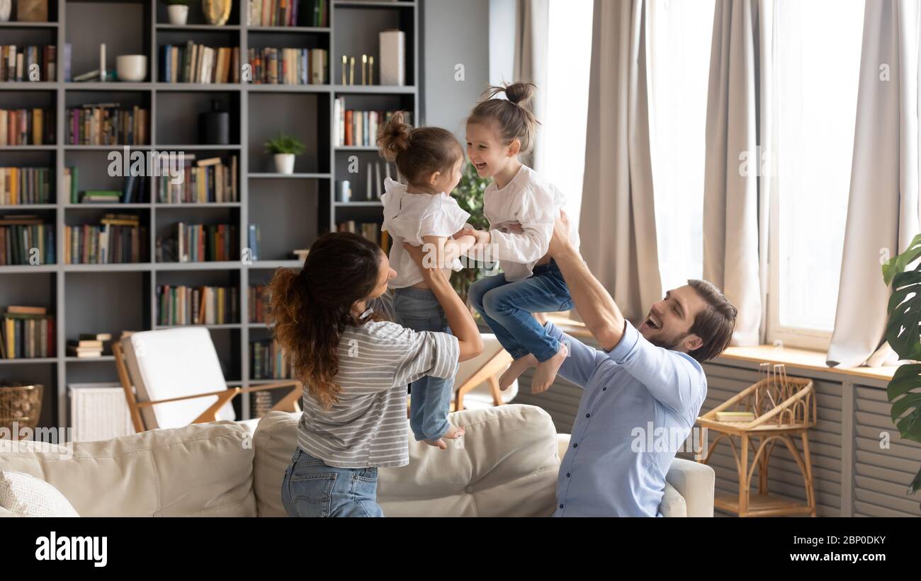Happy parents have fun playing with small daughters Stock Photo - Alamy