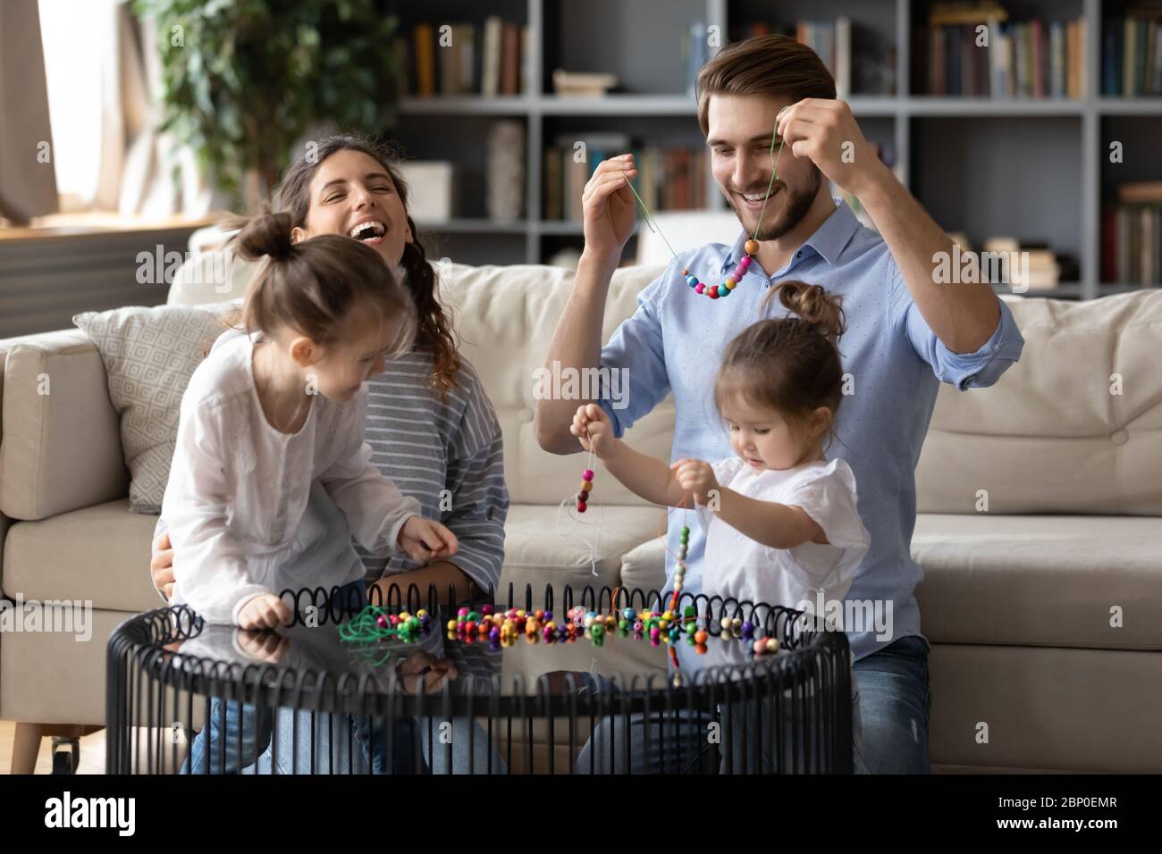 Happy young parents have fun playing with daughters Stock Photo - Alamy