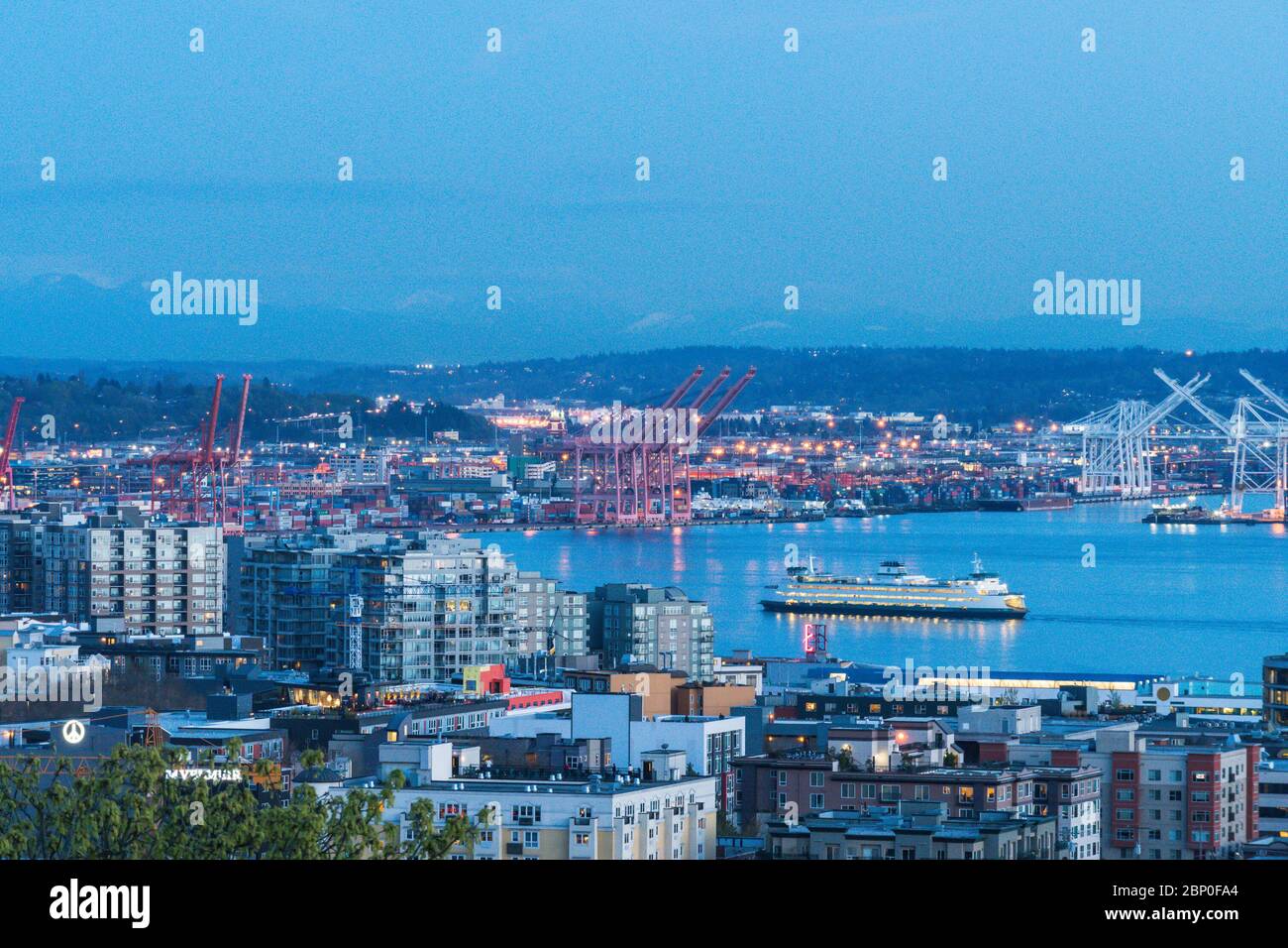 big ferry moving into downtown Seattle with industrail port background ...
