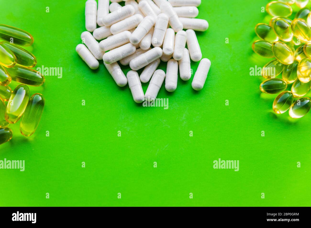 Groups of white vitamin supplements with stack of yellow jelly pills ...