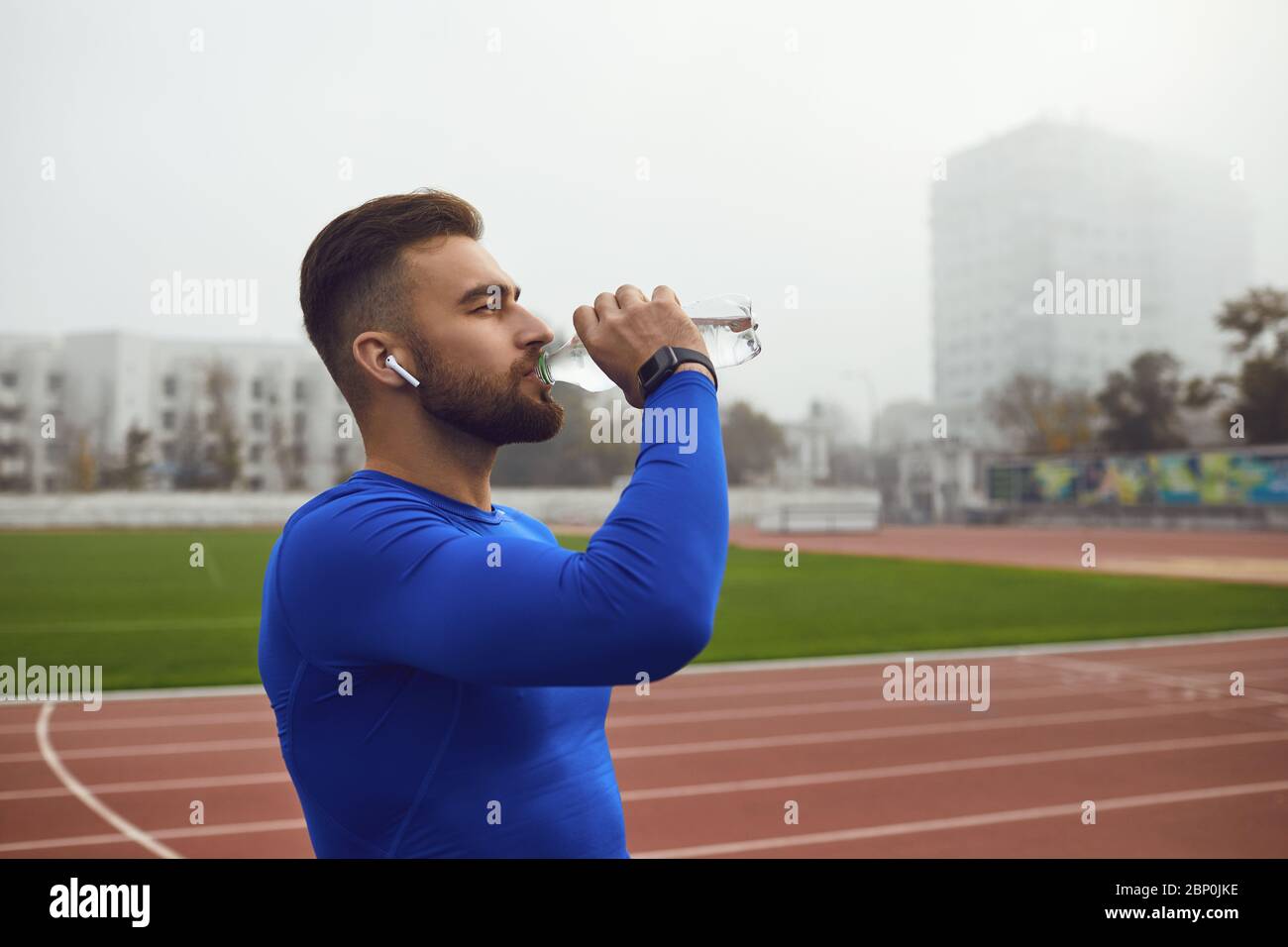 Athletic man with a bottle of water in training at the stadium Stock ...