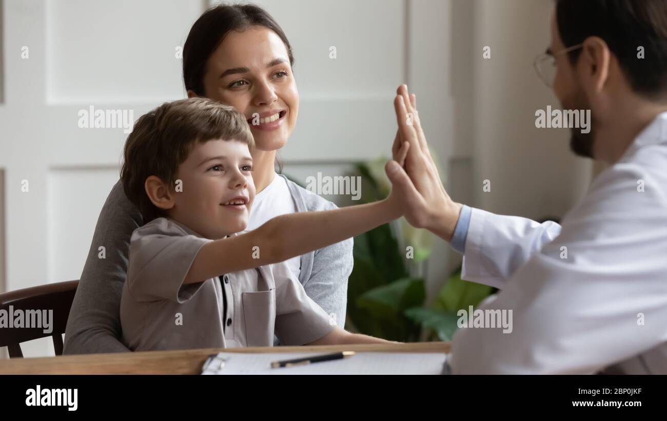 Male doctor and little boy patient greeting at consultation Stock Photo ...