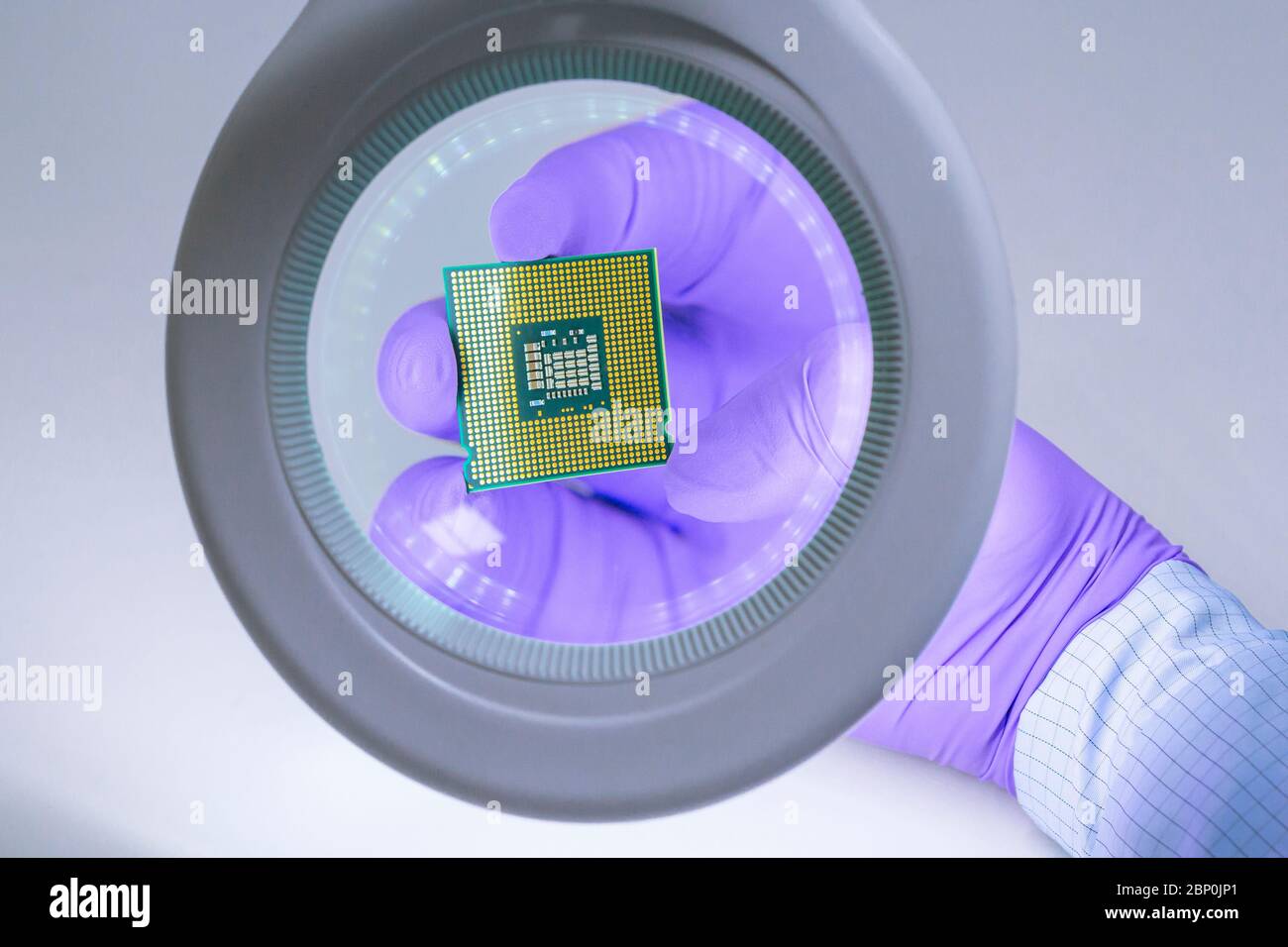 First-person view. A hand in a blue glove holds a processor chip and ...