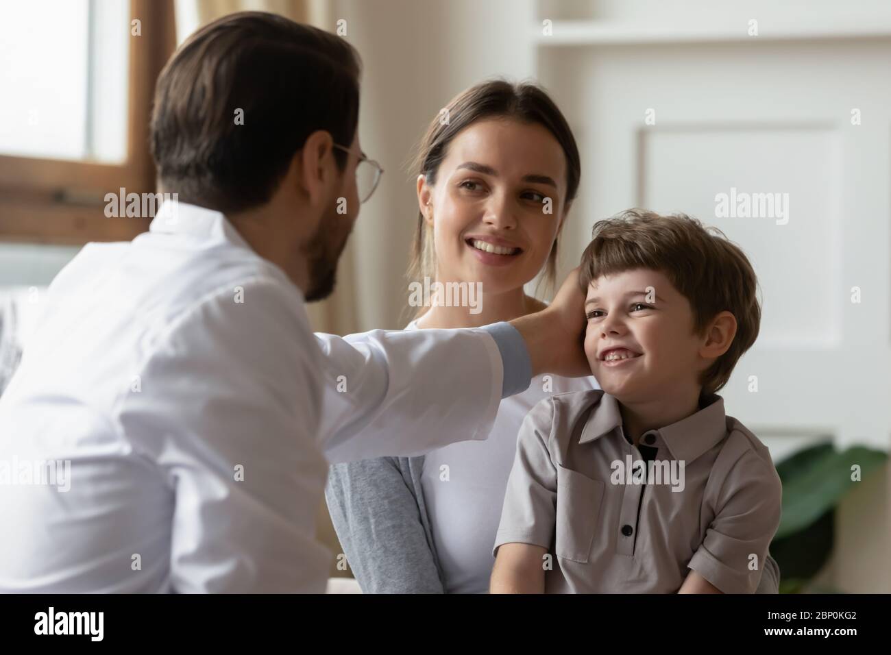 Caring male pediatrician comfort small boy patient Stock Photo - Alamy