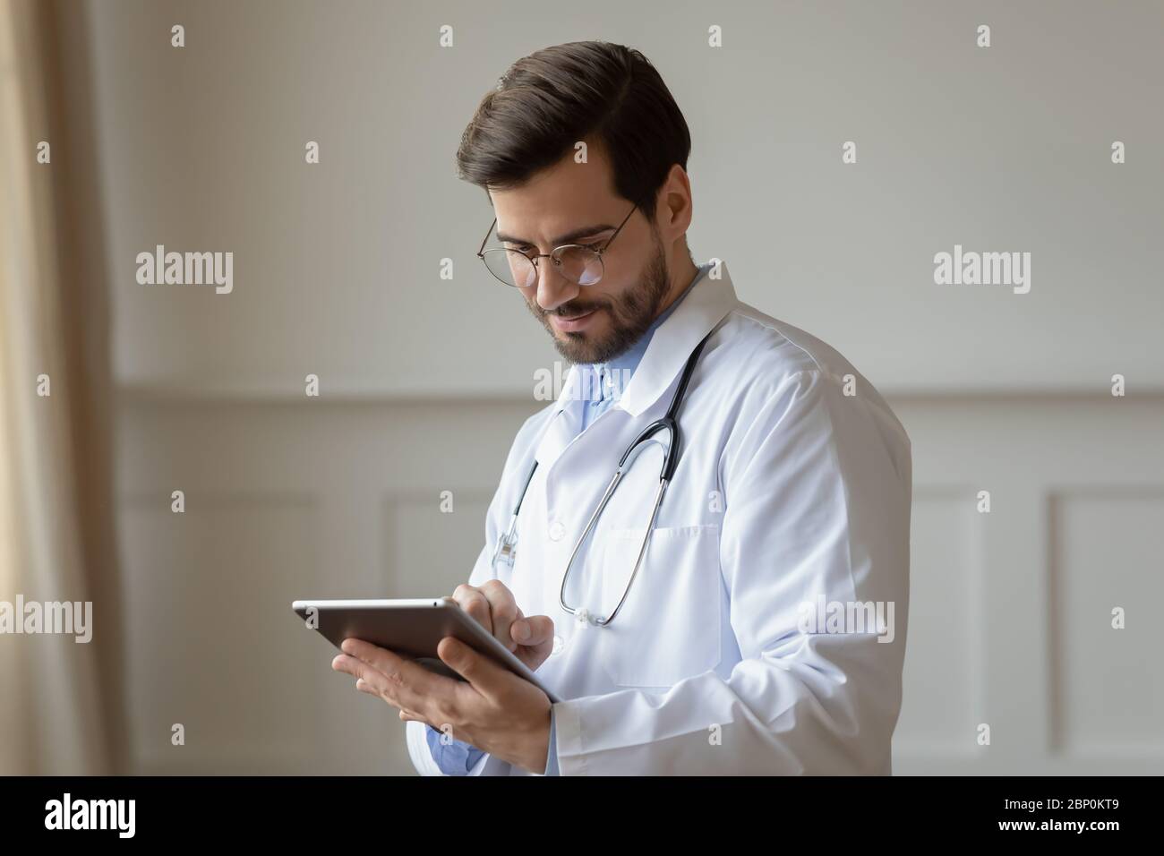 Male doctor using tablet gadget in modern hospital Stock Photo - Alamy