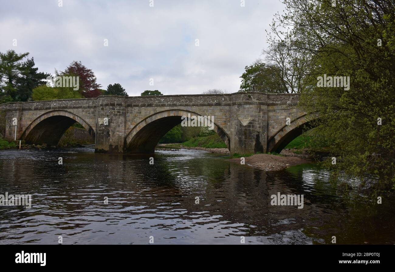 Unusual stoen bridge with arches over a river way Stock Photo - Alamy