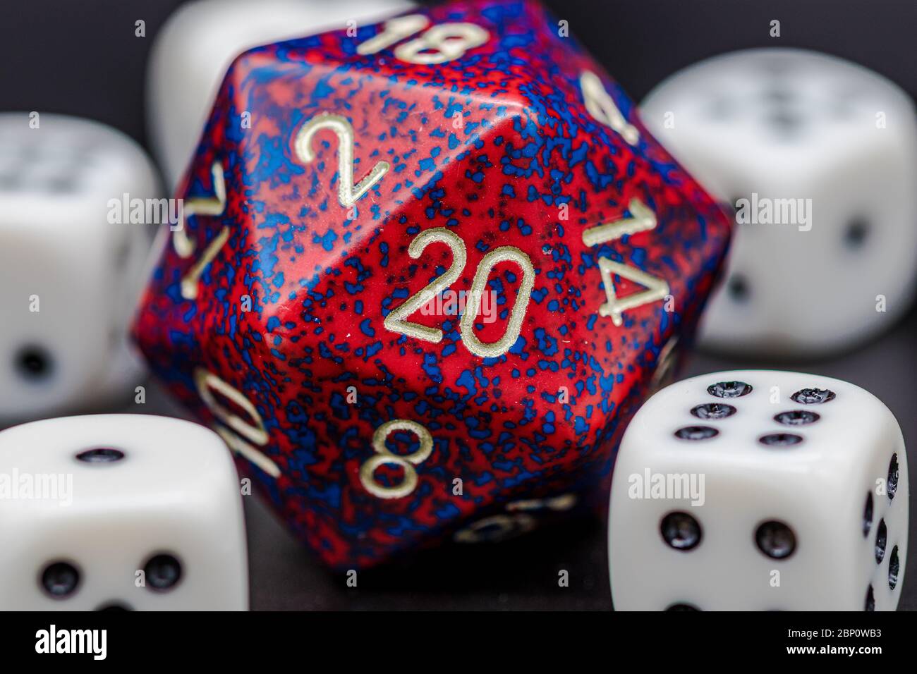 Macro closeup of several dice in front of dark background with 20-sided ...