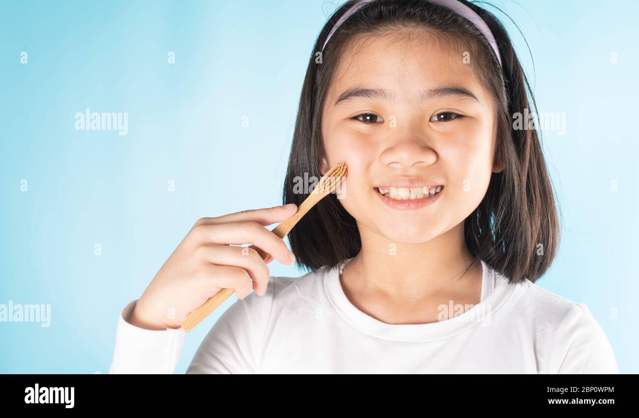 An Asian child is holding a toothbrush. To show the preference of care ...