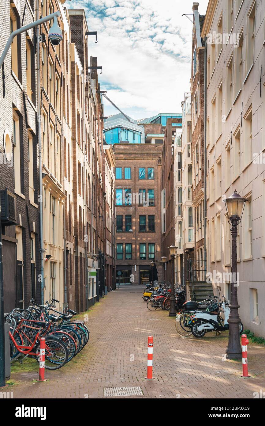 Typical narrow street in Amsterdam with dancing houses and bikes ...