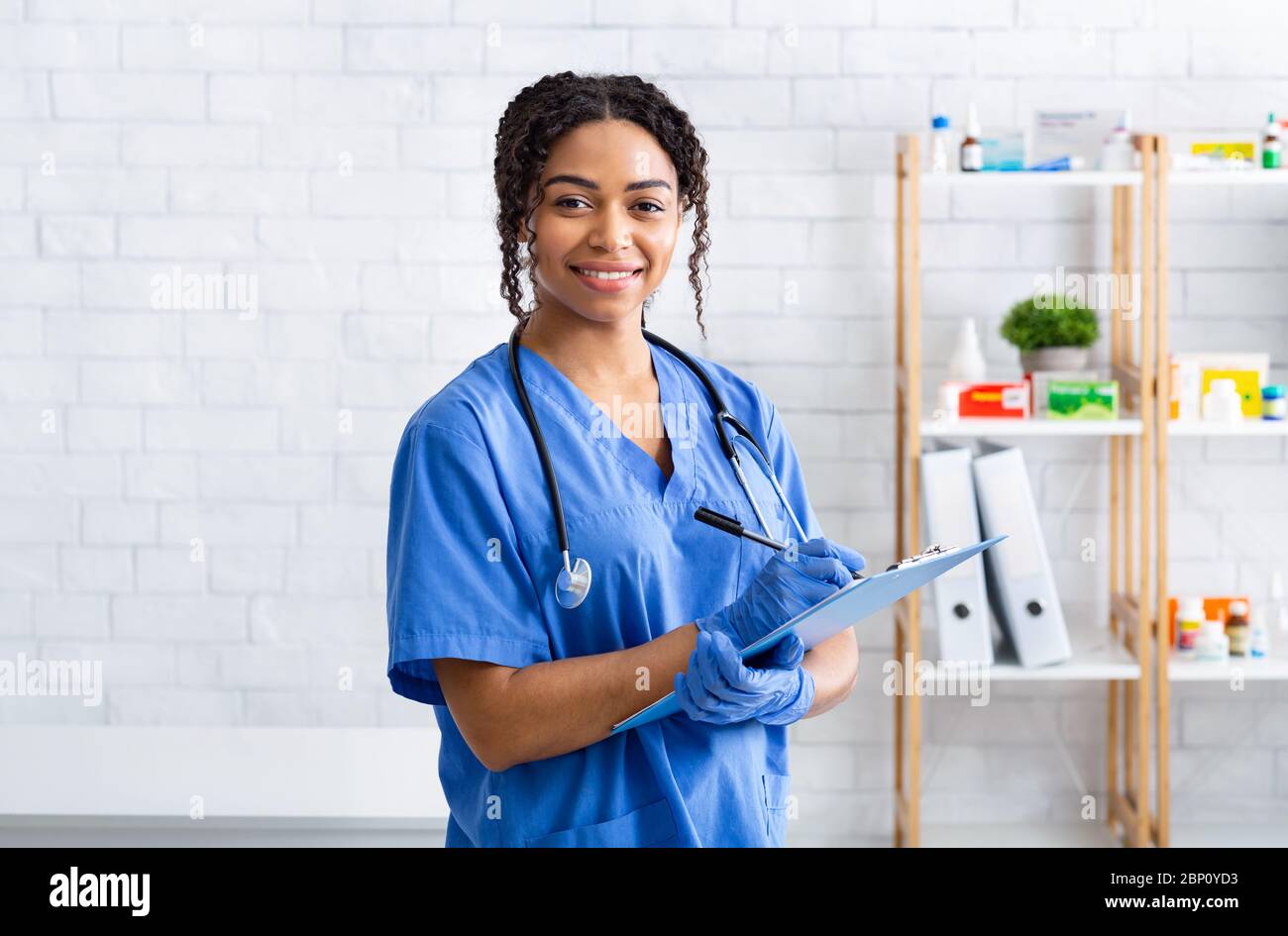 Smiling African American veterinarian doc with clipboard in clinic ...