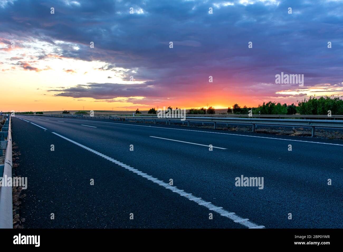 Empty highway of vehicles with a dramatic sunset sky Stock Photo - Alamy