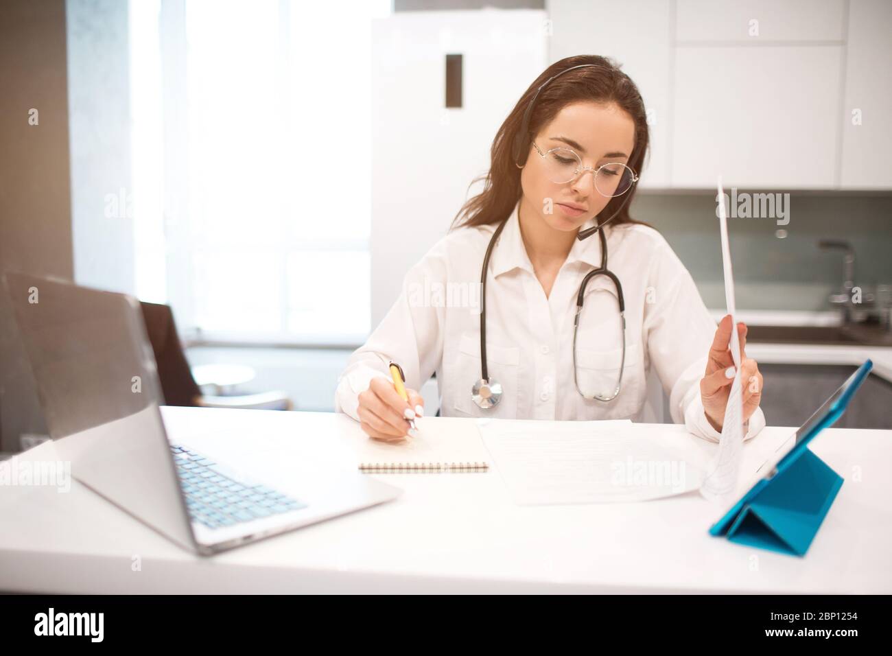 telemedicine. A woman doctor is working from home because of the Cowid ...