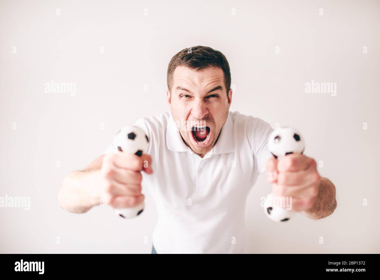 Young man isolated over white background. Emotional guy hold dumbbells ...
