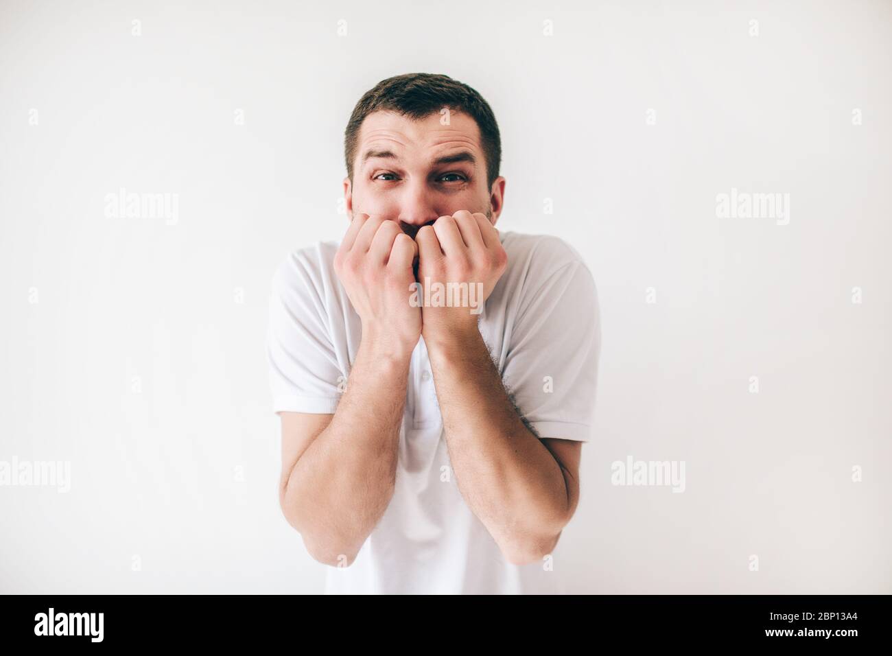 Young man isolated over white background. Guy afraid terrified and ...