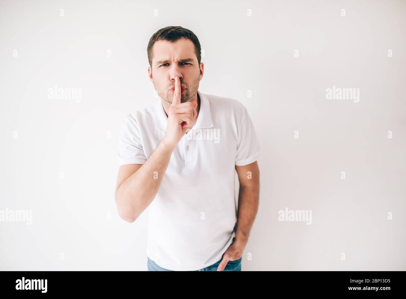 Young man isolated over white background. Guy stand alone in studio and ...
